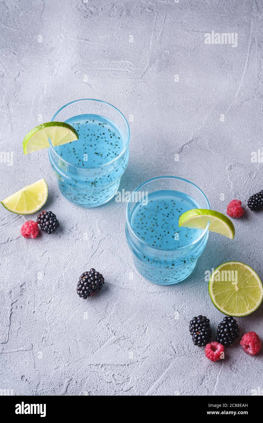 Tasty blue colored cocktail drink with basil chia seeds, citrus lime ...