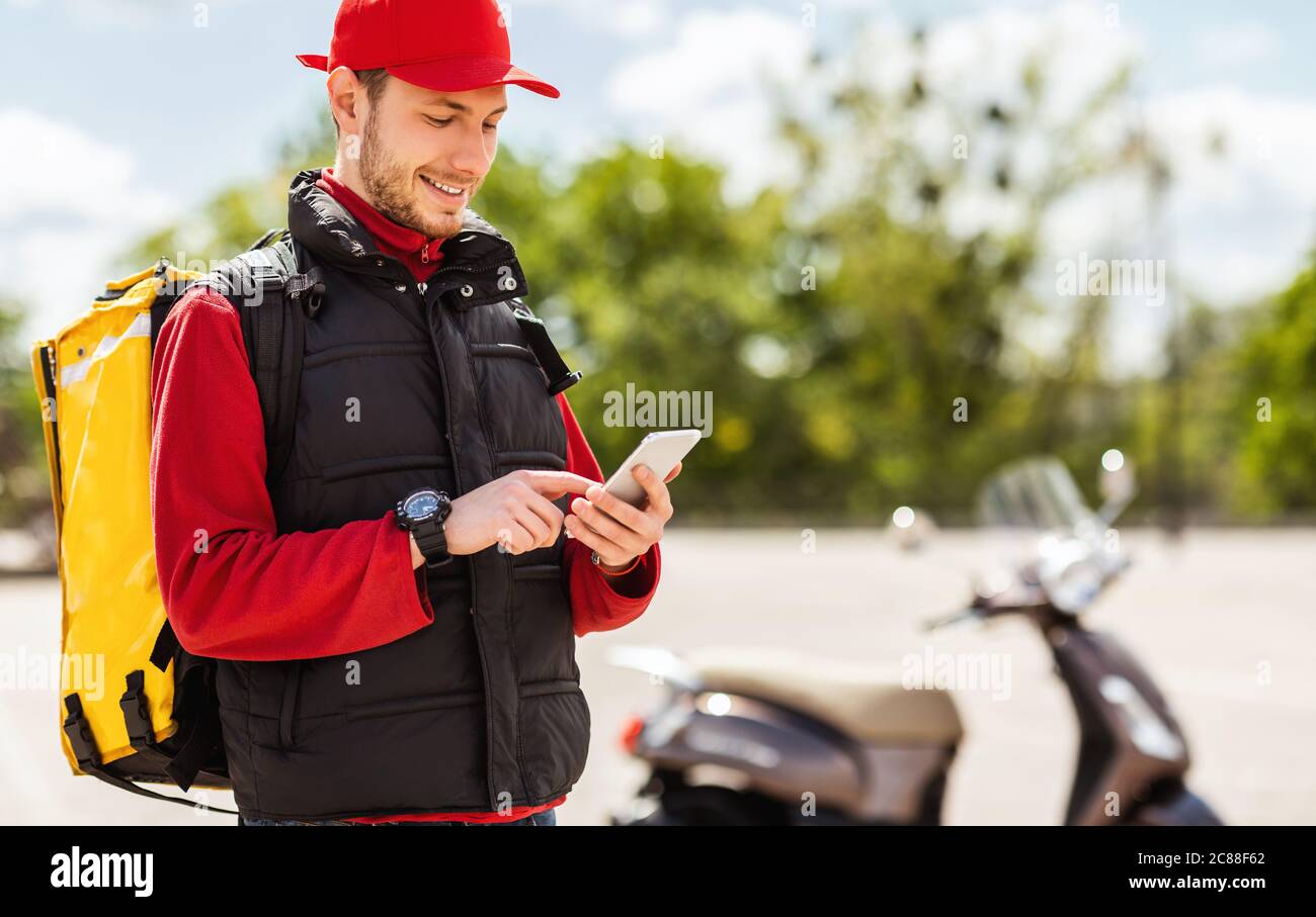 Delivery Man Using Smartphone Delivering Food On Scooter Standing ...