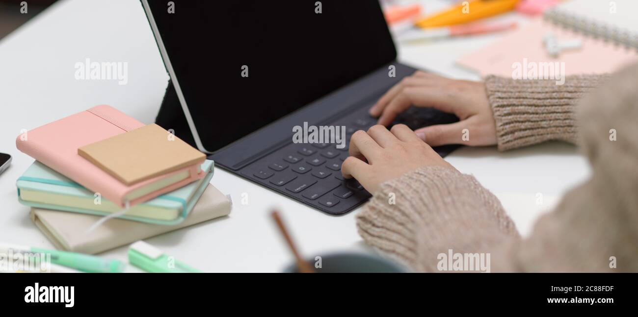Close up view of female student doing assignment with digital tablet ...