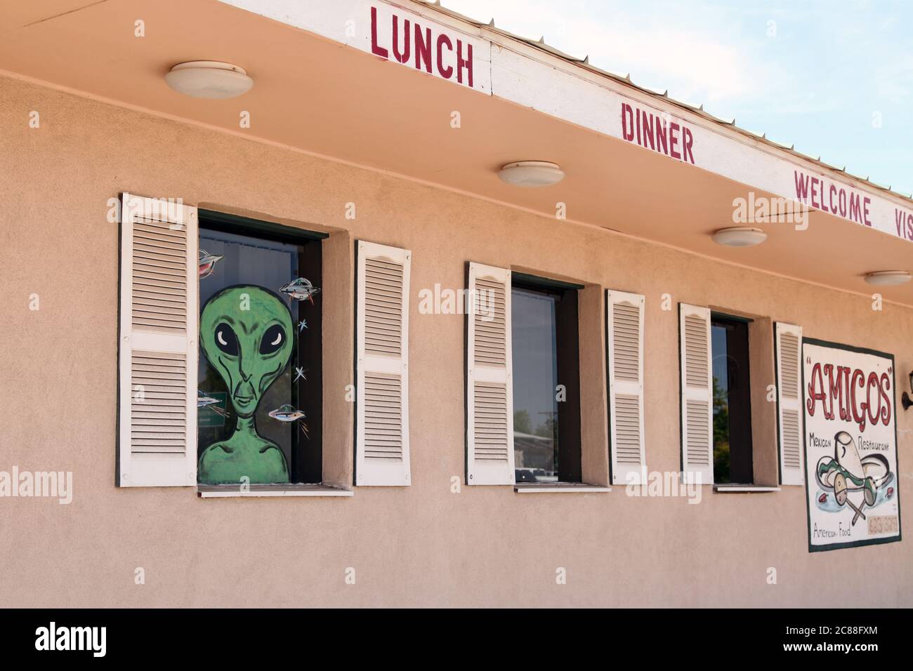 An illustration of an alien looking out of window at Amigos diner ...