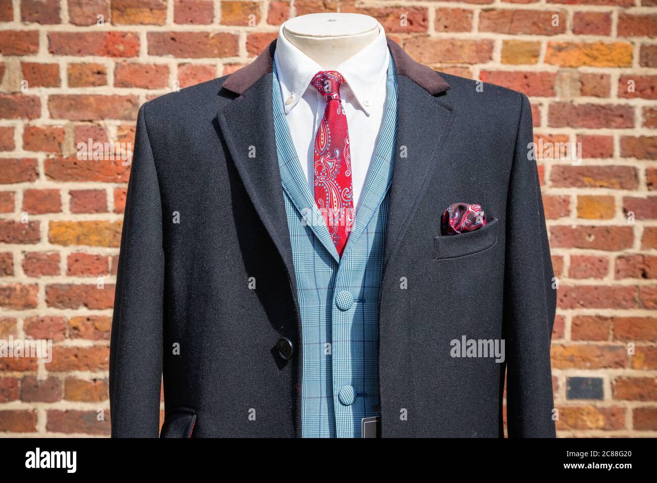 Traditional English three-piece suit on display with red brick ...