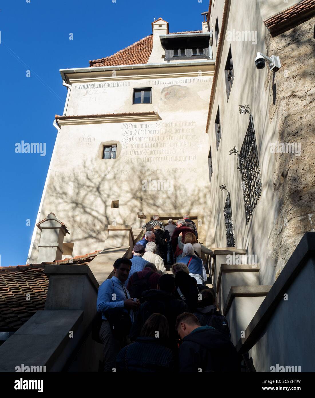 Tourists waiting in que at main entrance to go inside Bran Castle. Old ...