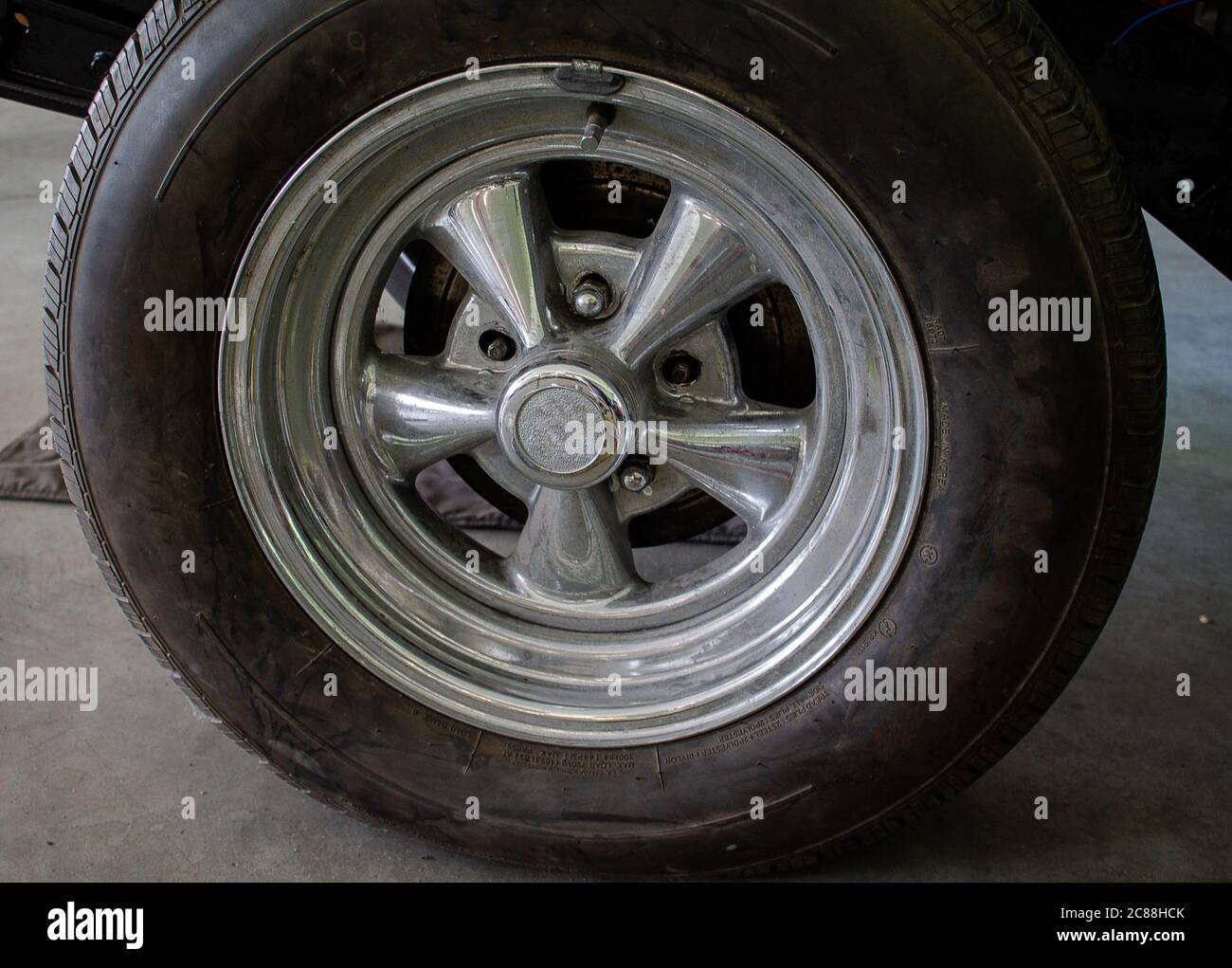 Photo of a muscle car to be restored. The tire and the original rim are ...