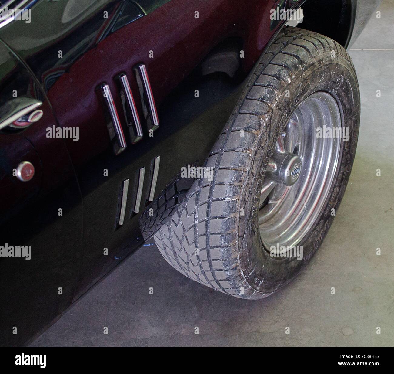 Photo of a restored muscle car. Also photographed is the tire and the ...