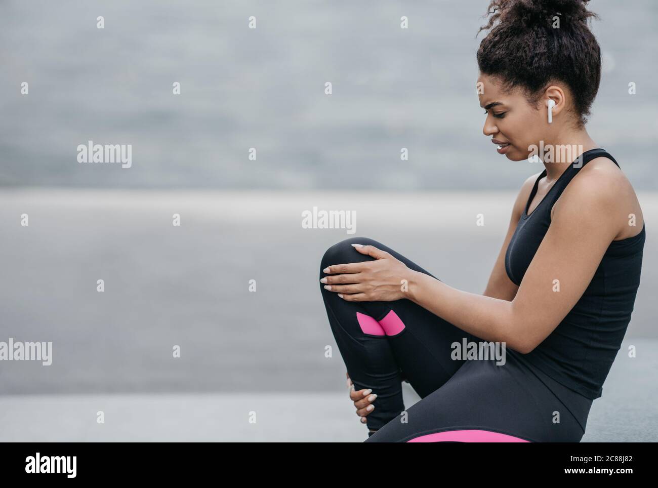 Bad training. Upset girl with wireless headphones holding to injured ...