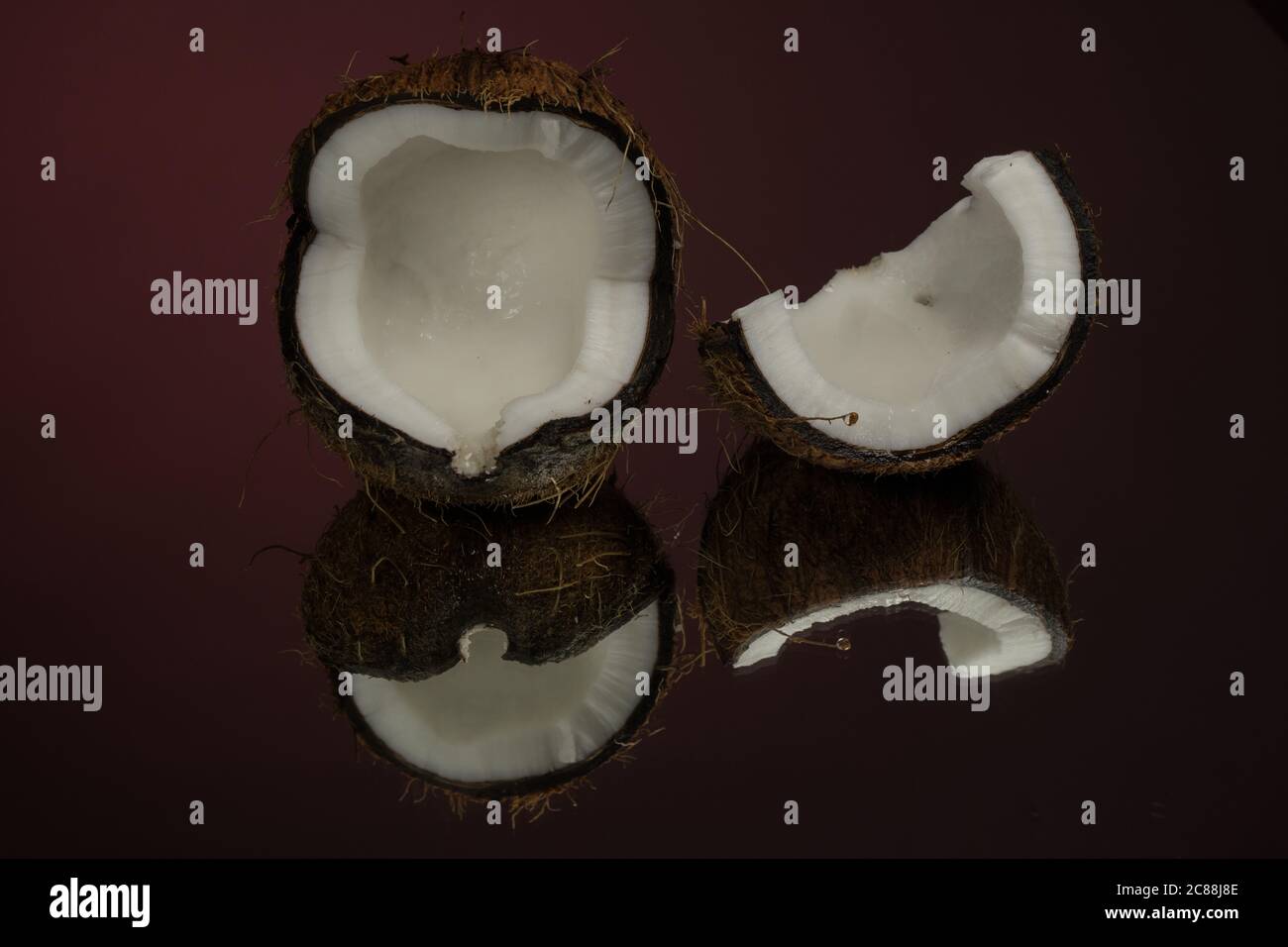 Coconut on a red background. Dark background Stock Photo - Alamy