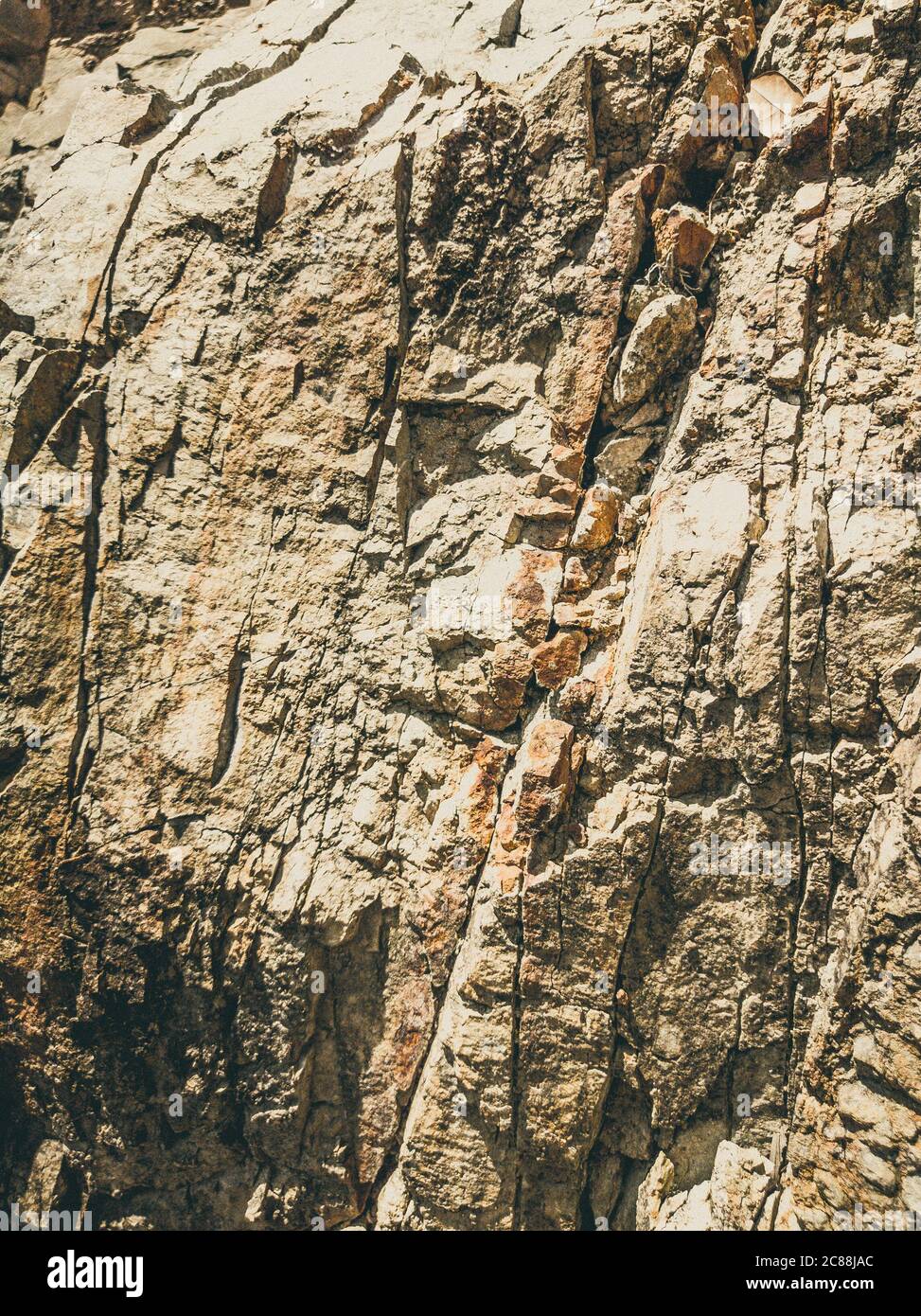 Natural background. Closeup edged shabby cliff cracks. Gray-brown stone ...
