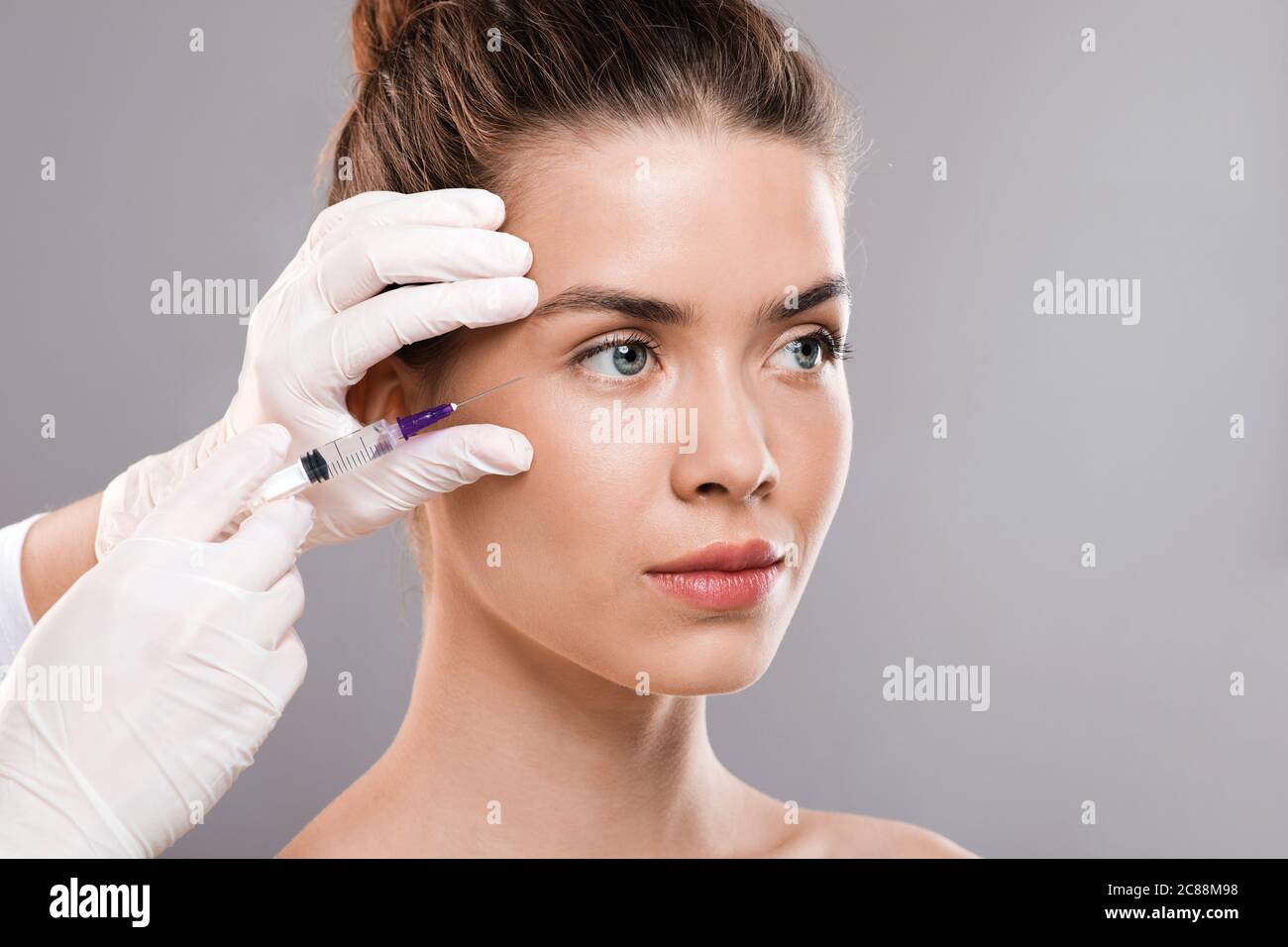 Attractive woman getting beauty injection, grey background Stock Photo ...