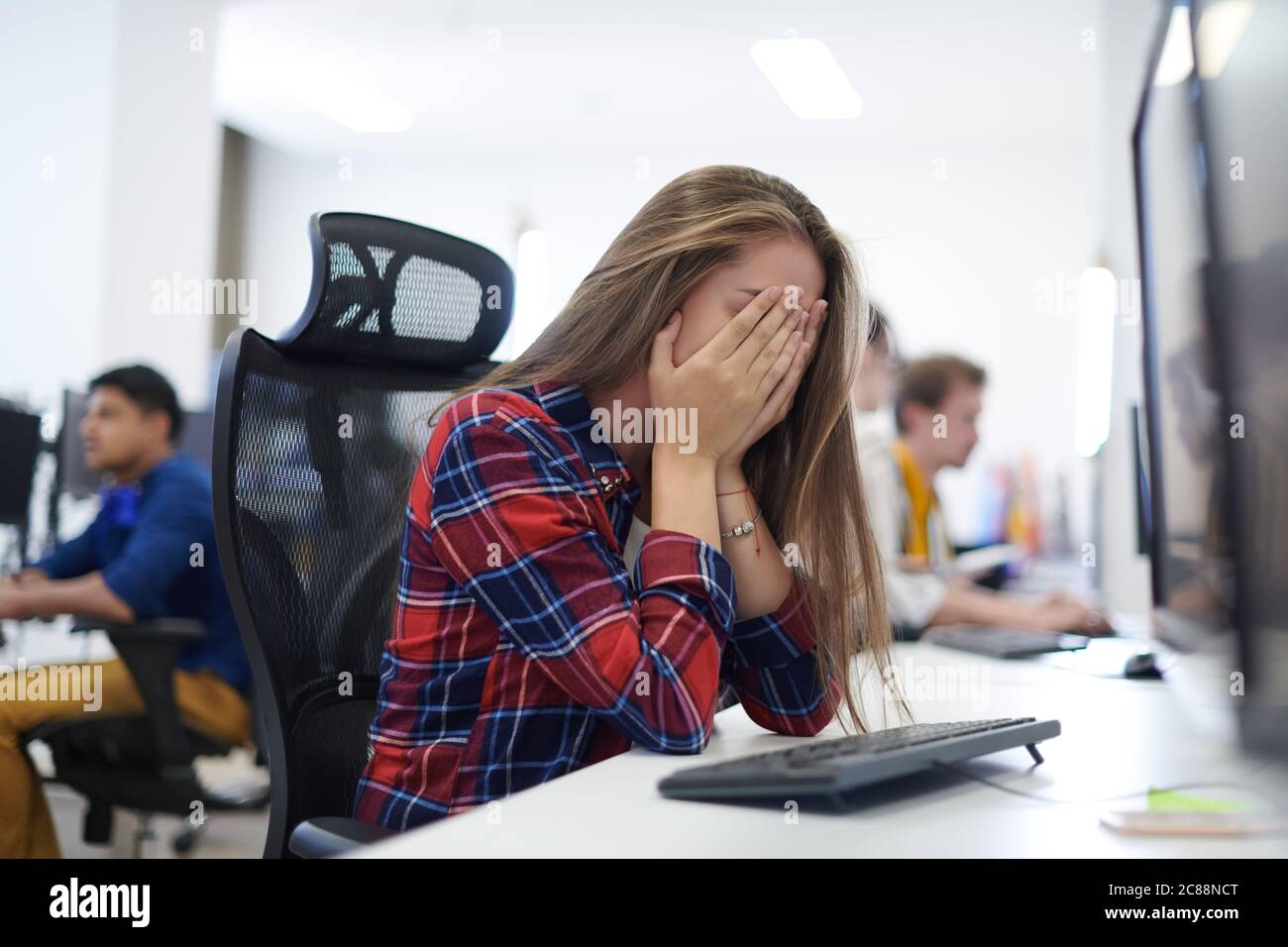 tired casual business woman taking a break while working on desktop ...