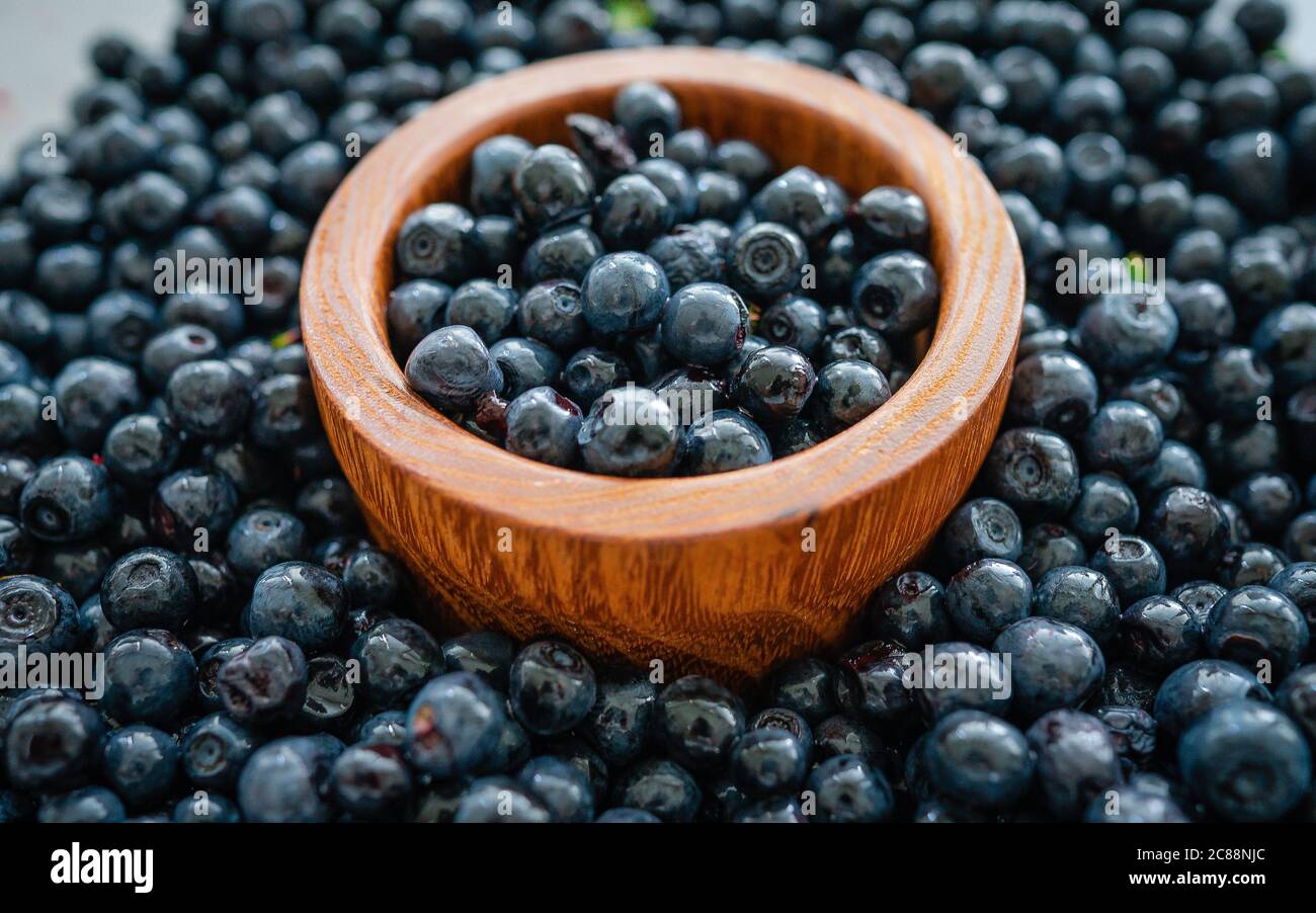 Wooden bowl full of fresh blueberries with herbs. Top view. Ripe ...