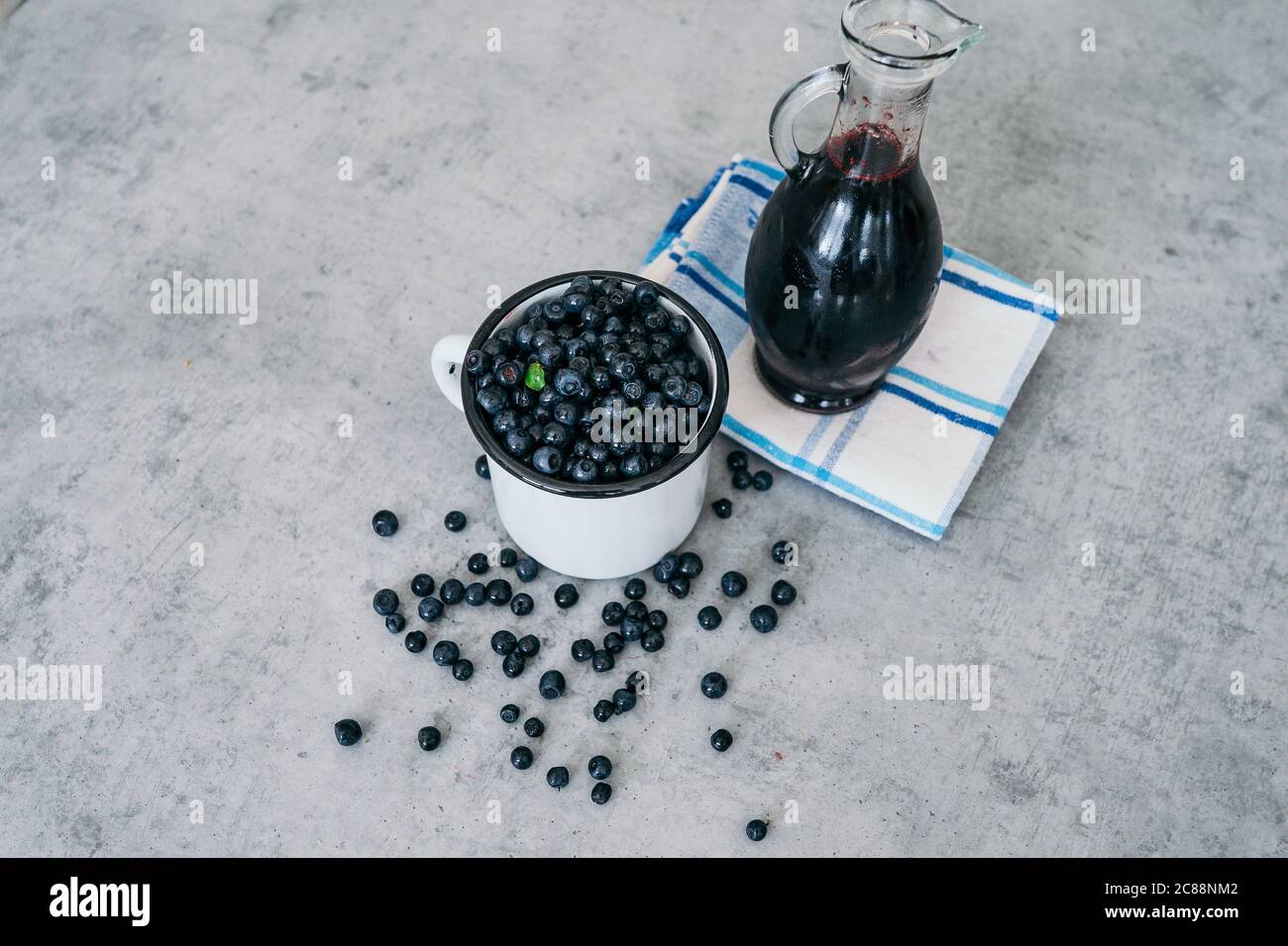 Fresh blueberry with drops of water in white cup. Blueberry syrup in ...