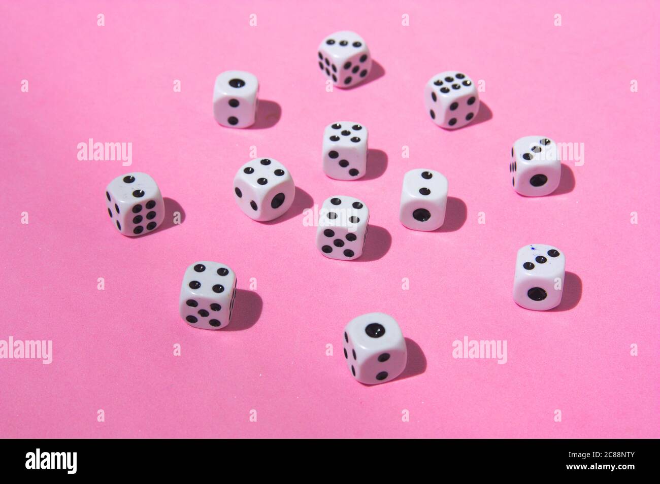 A few white dice decorated with black dots on their faces set against a ...