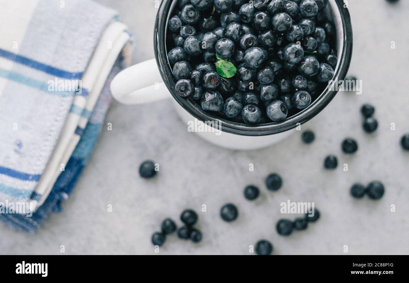 Fresh blueberry with drops of water in white bowl. Top view. Concept of ...
