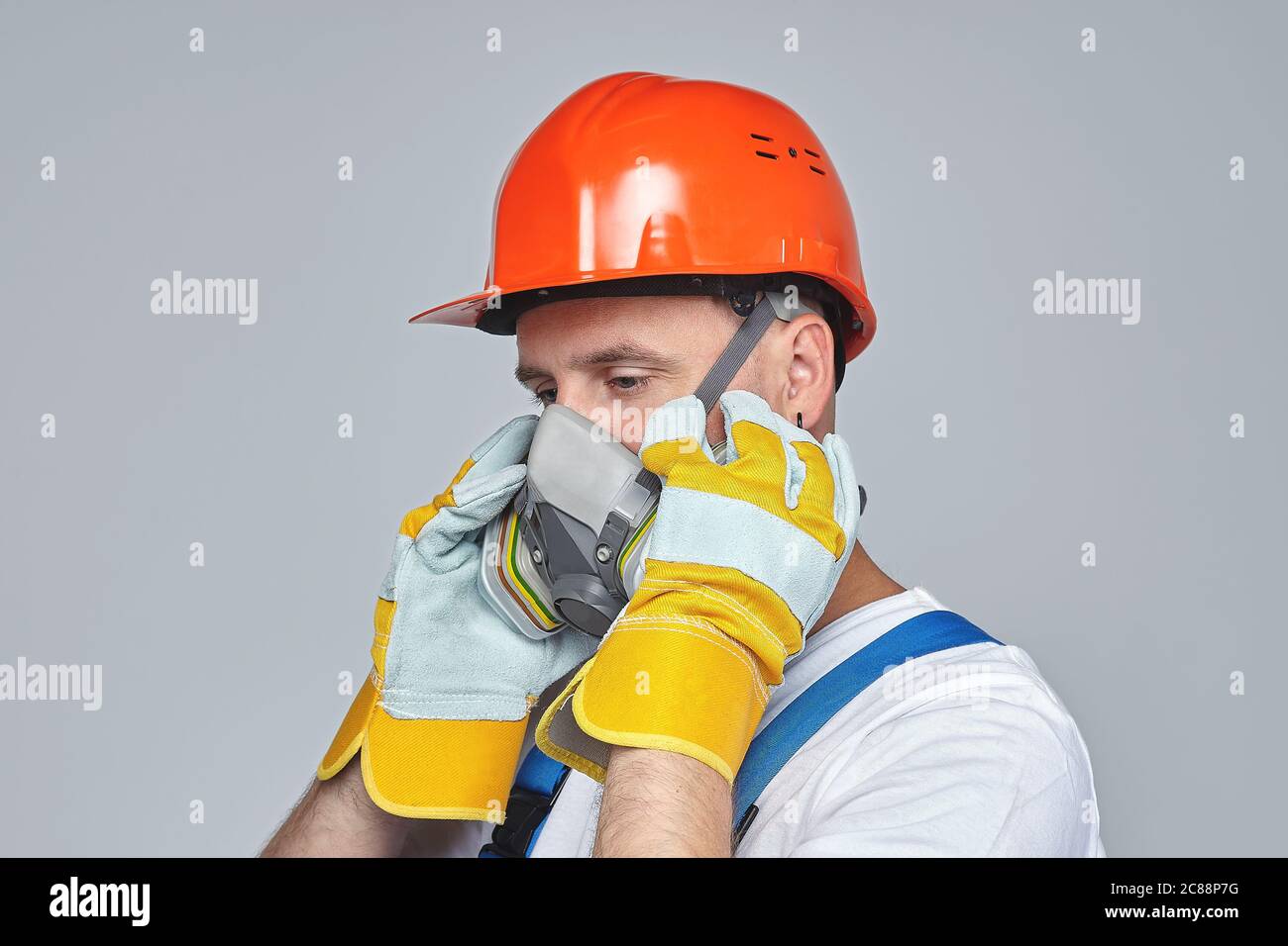 adult male in a construction helmet and a respirator. photo session in ...