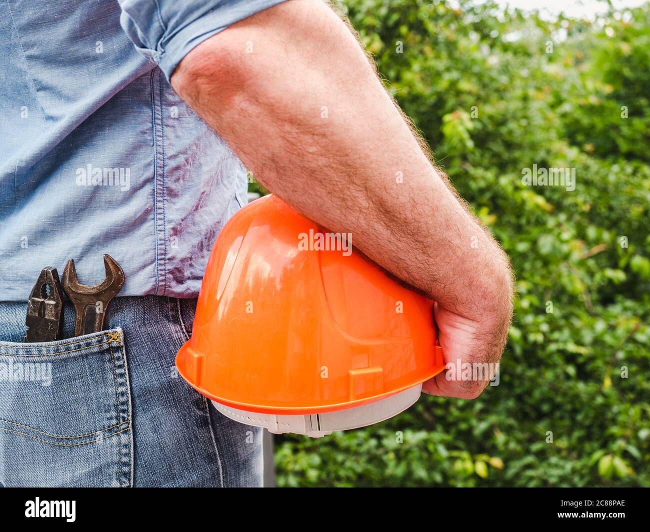 Man with tools, holding a safety helmet Stock Photo - Alamy
