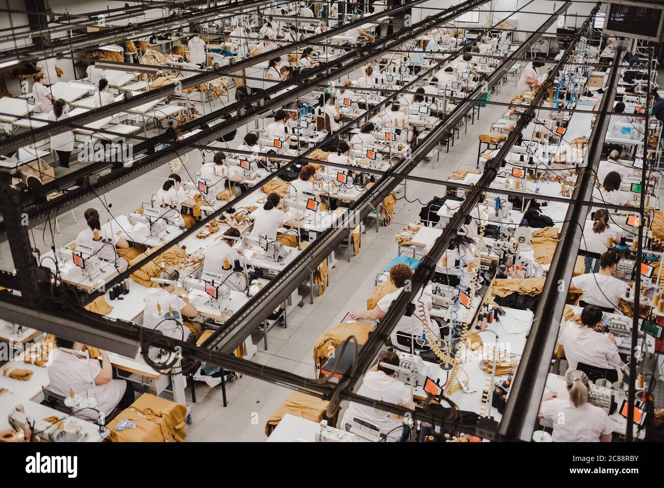 Top view of a busy textile sewing factory with female workers Stock ...