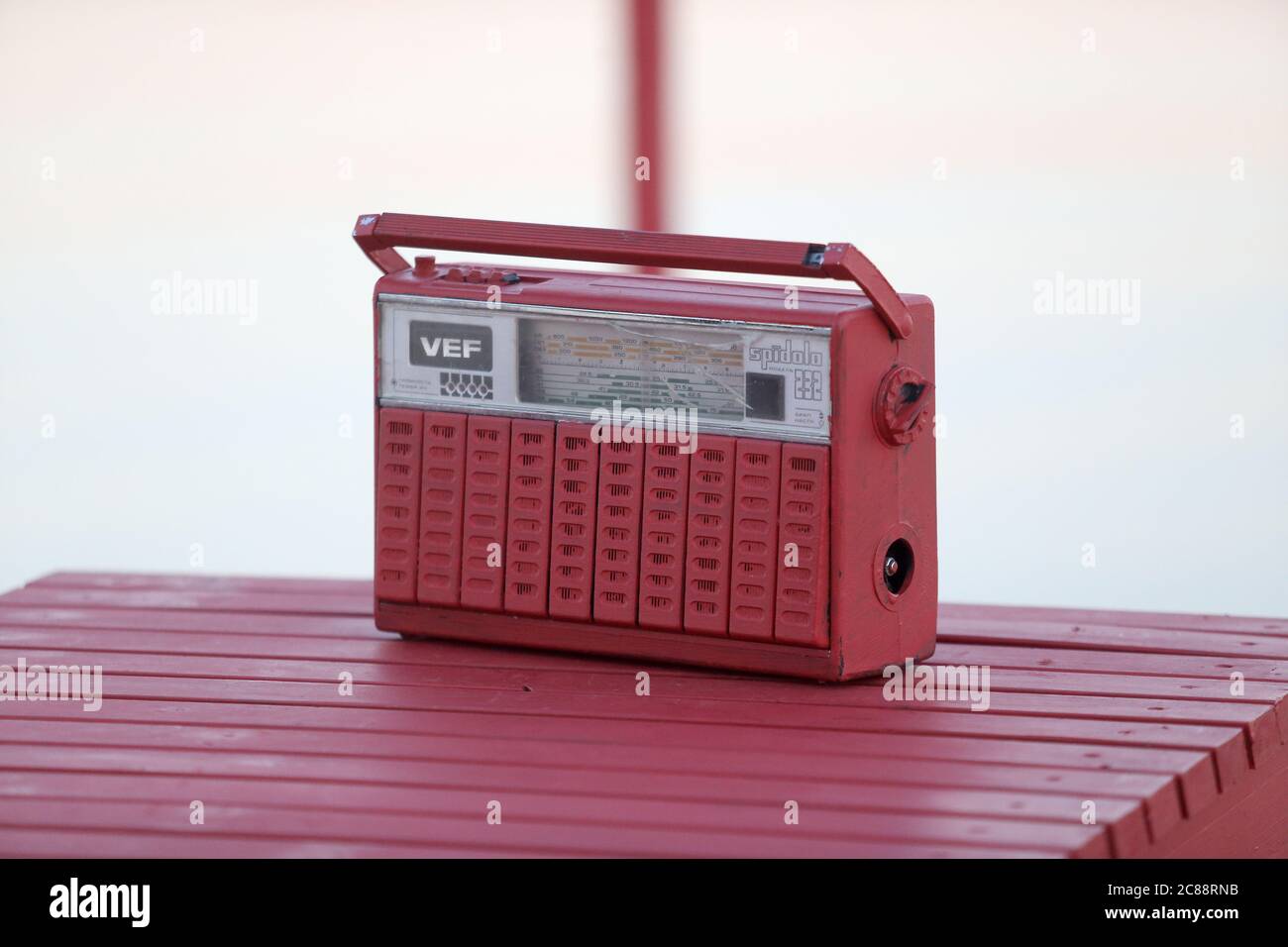 Old red vintage radio on a red table, some interior artwork. Lithuania ...