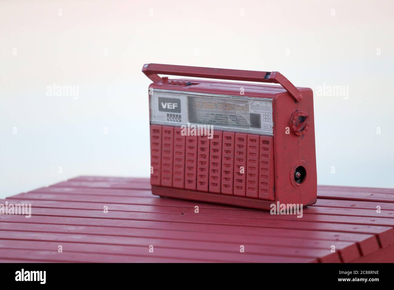 Old red vintage radio on a red table, some interior artwork. Lithuania ...
