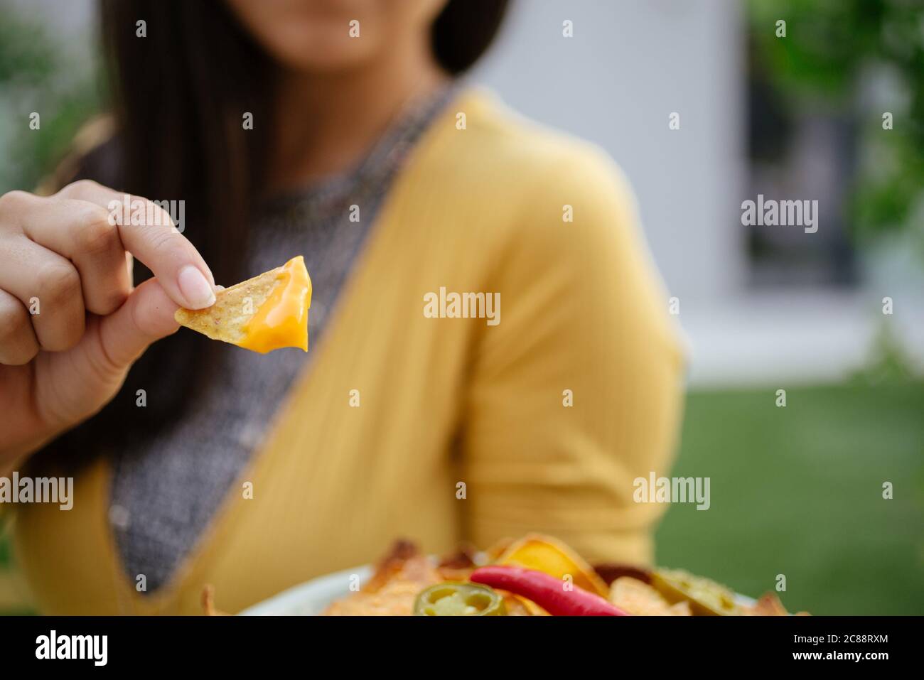 Female eating crisps with yellow sauce Stock Photo - Alamy