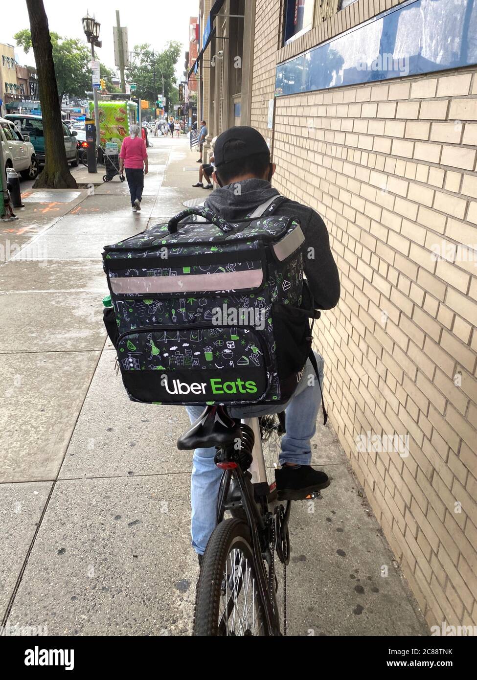 Uber Eats bicycle delivery manstops to look at his phone on the ...