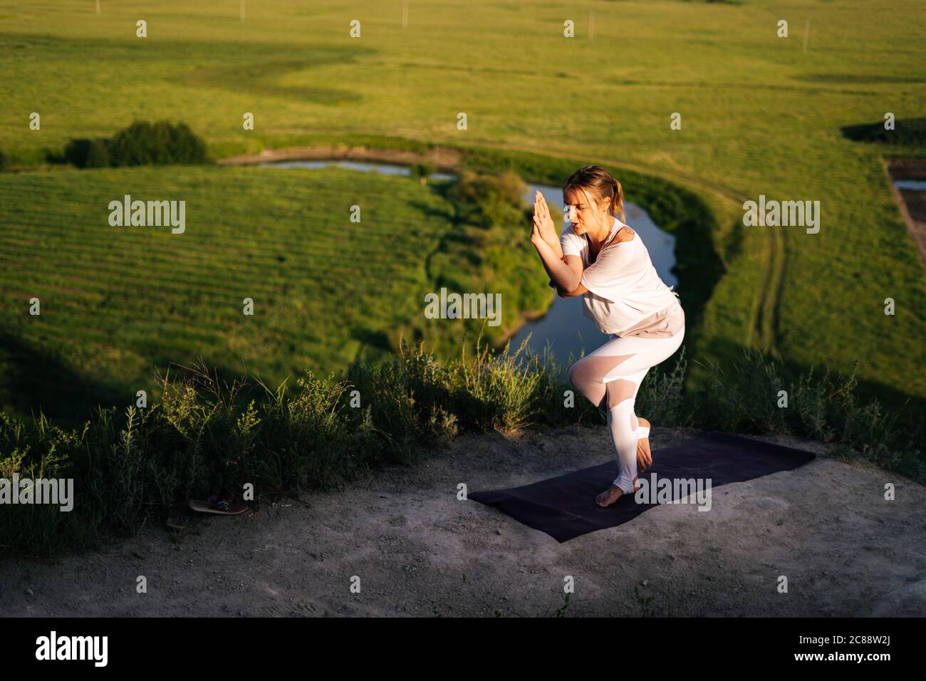 Concentrated relaxed woman practicing yoga, standing in Eagle exercise ...