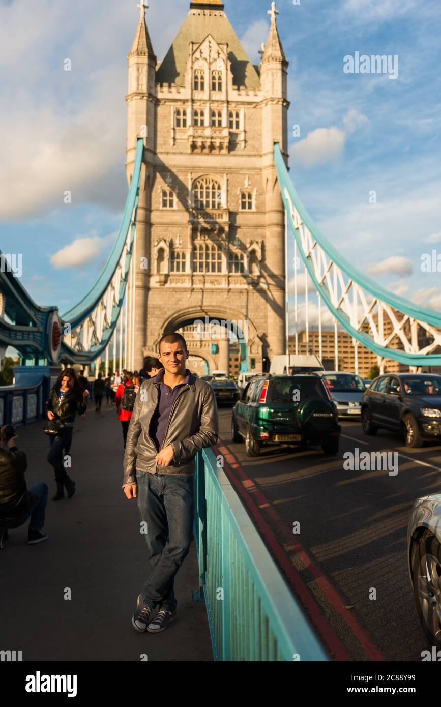 Young man male tourist posing for photo at the Tower Bridge in Lonodn ...