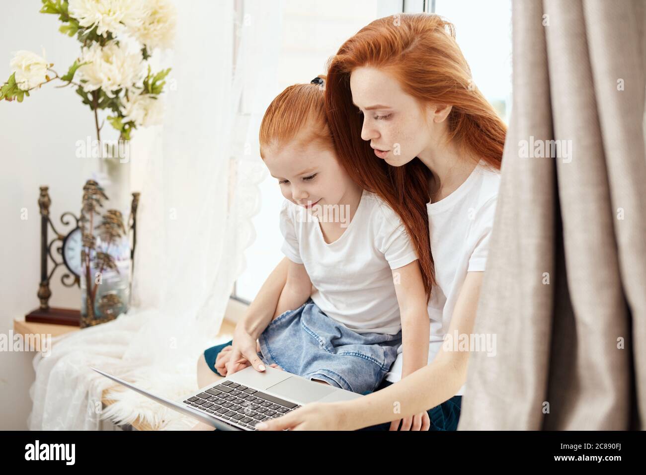 Precious time together. Lovely red-haired family watching video for ...