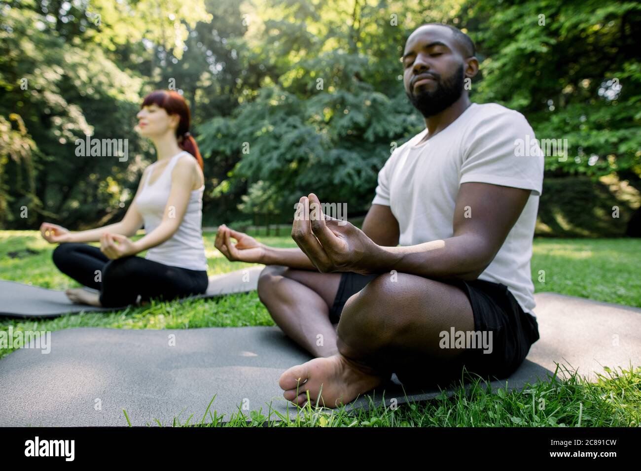 Close up of young African man sitting in lotus yoga position, zen ...