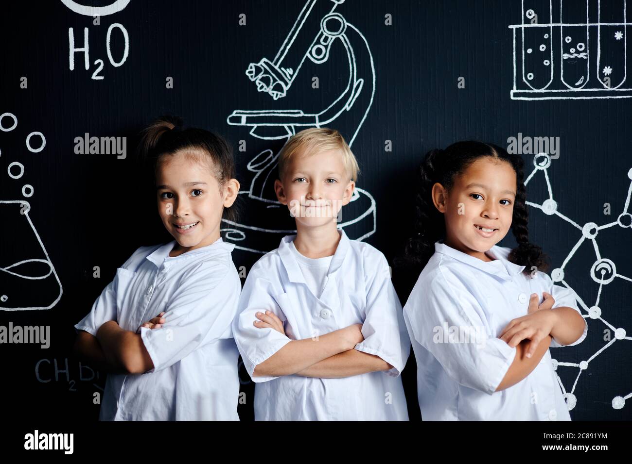 Three little cute scientists kids looking at camera while visiting ...