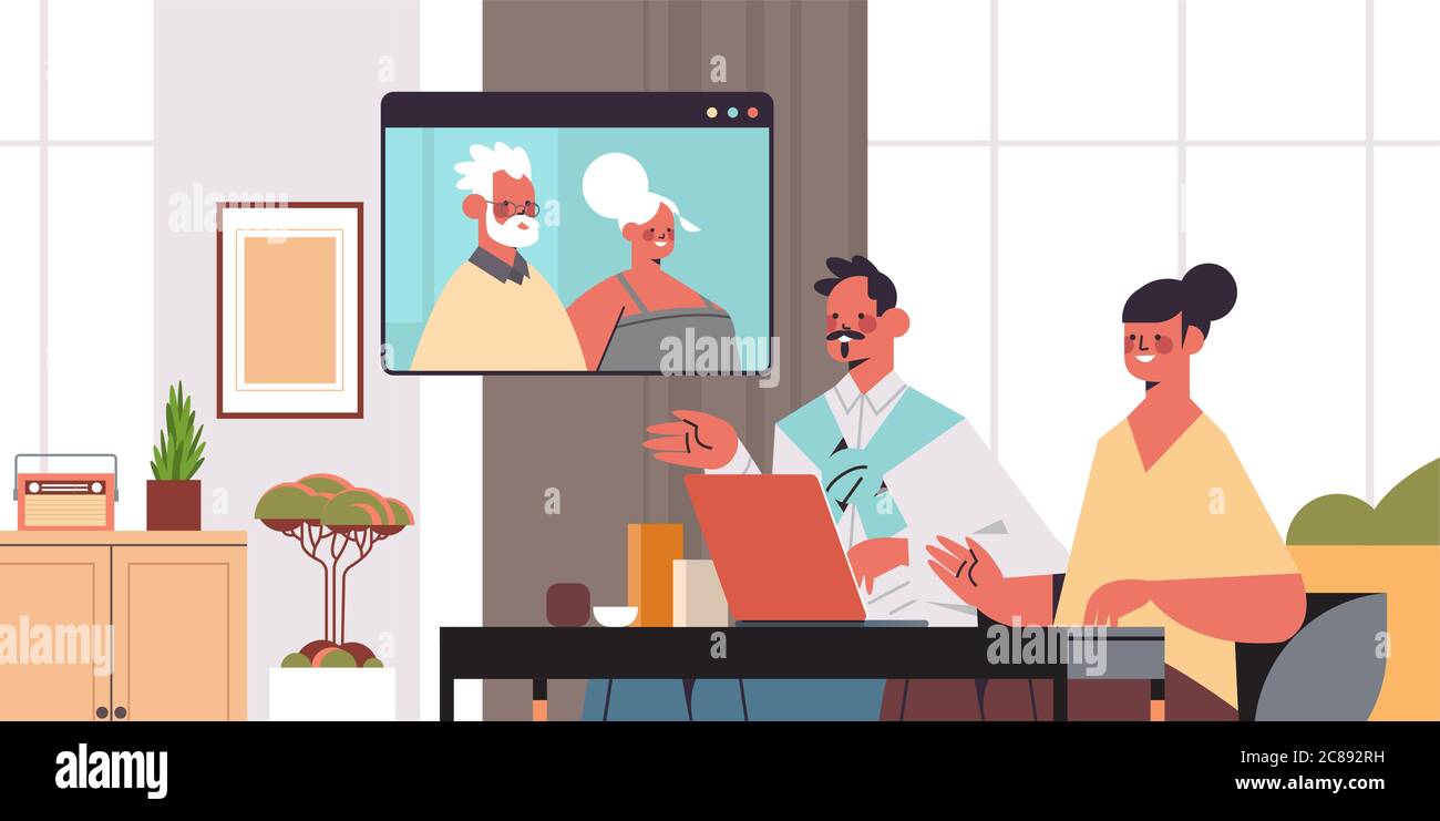 young couple having virtual meeting with grandparents during video call ...