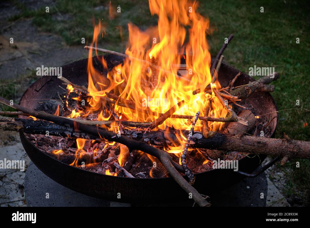 A natural bonfire with wooden sticks and branches is burning in a fire ...
