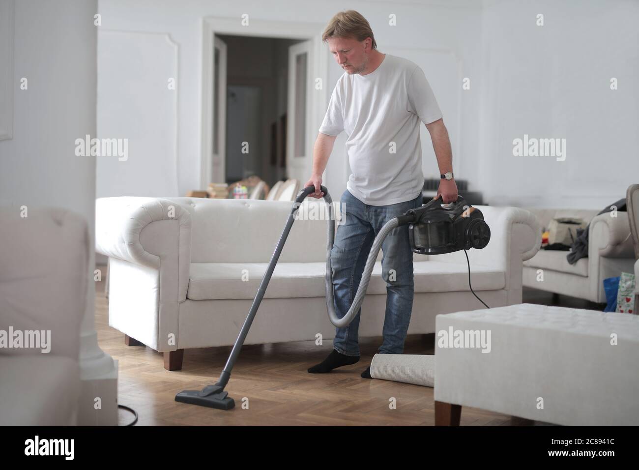 Male cleans house with vacuum cleaner Stock Photo - Alamy
