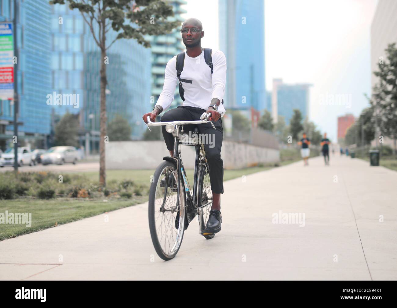 Young black male riding a bicycle on the street - healthy lifestyle ...
