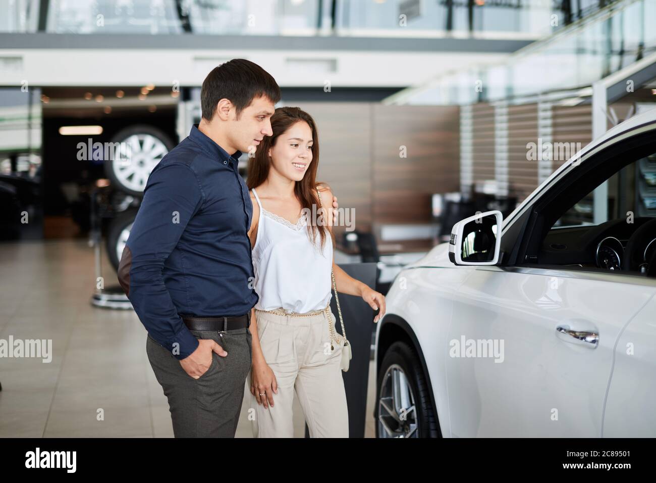 Professional salesman selling luxury car to beautiful female buyer at ...