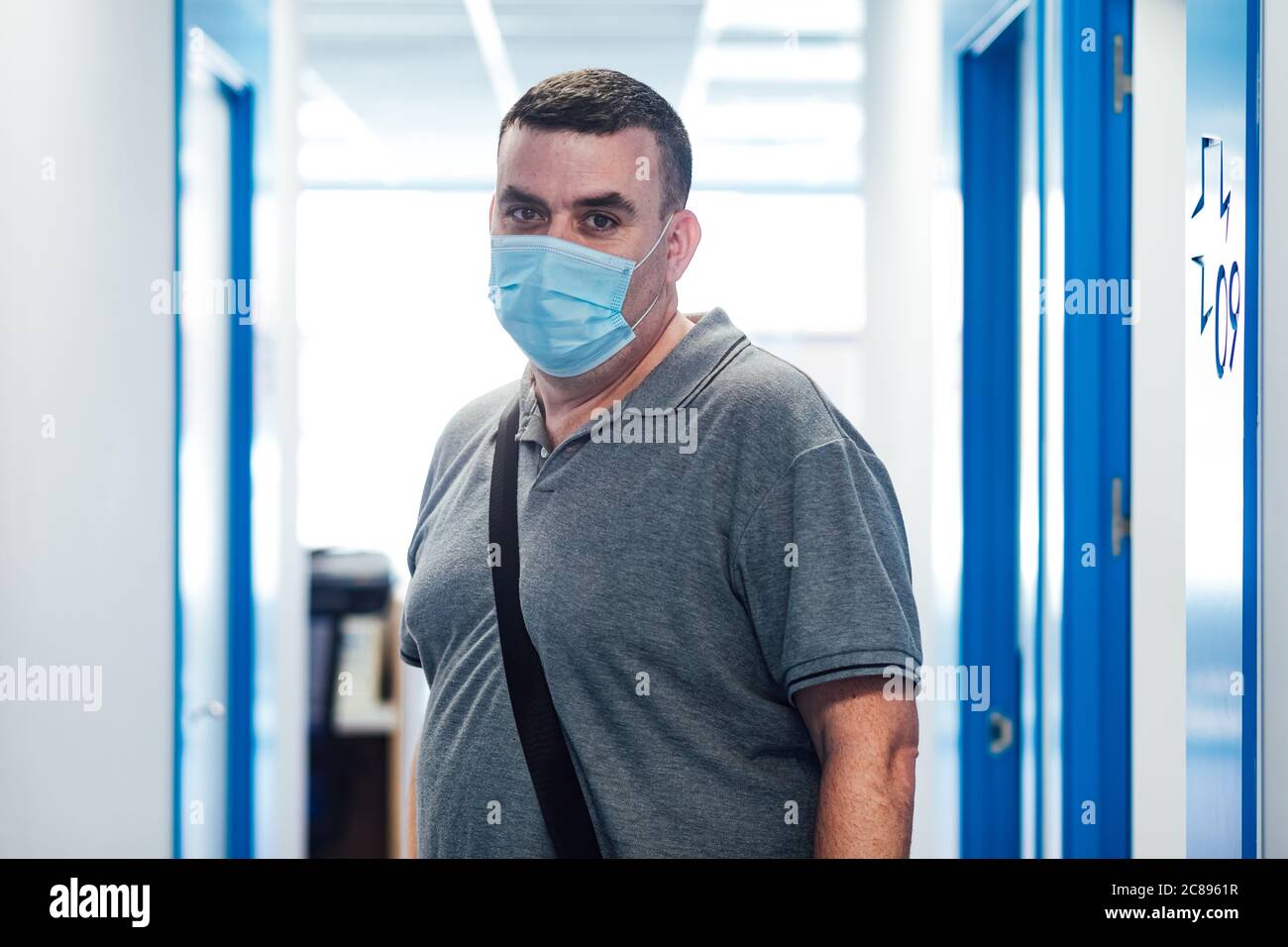 Chubby patient wearing face mask leaving a medical consultation Stock ...