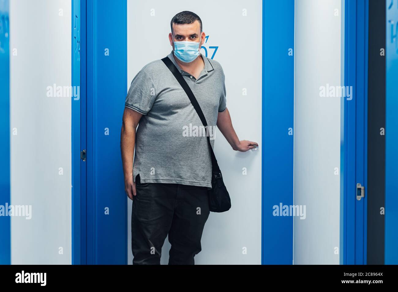 Chubby patient wearing face mask leaving a medical consultation Stock ...