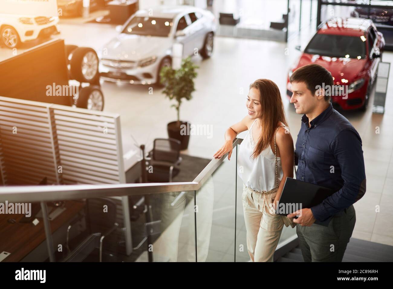Buying their first car together. High angle view of young car salesman ...