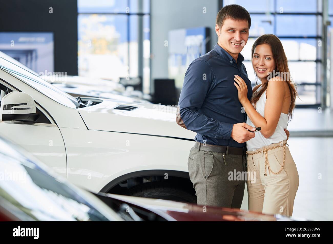 Happy caucasian couple dressed in summer time wear hugging in front of ...