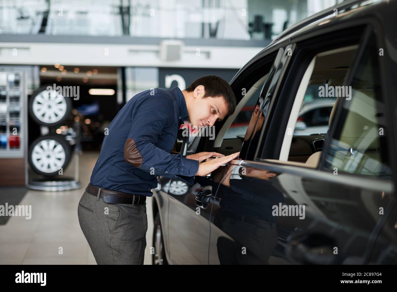 Professional salesman checking out interior and design of a new car at ...