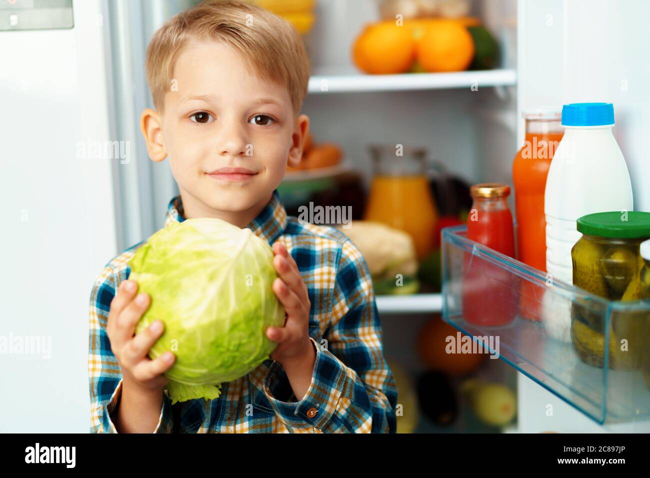 Little boy standing in front of open fridge and choosing food Stock ...