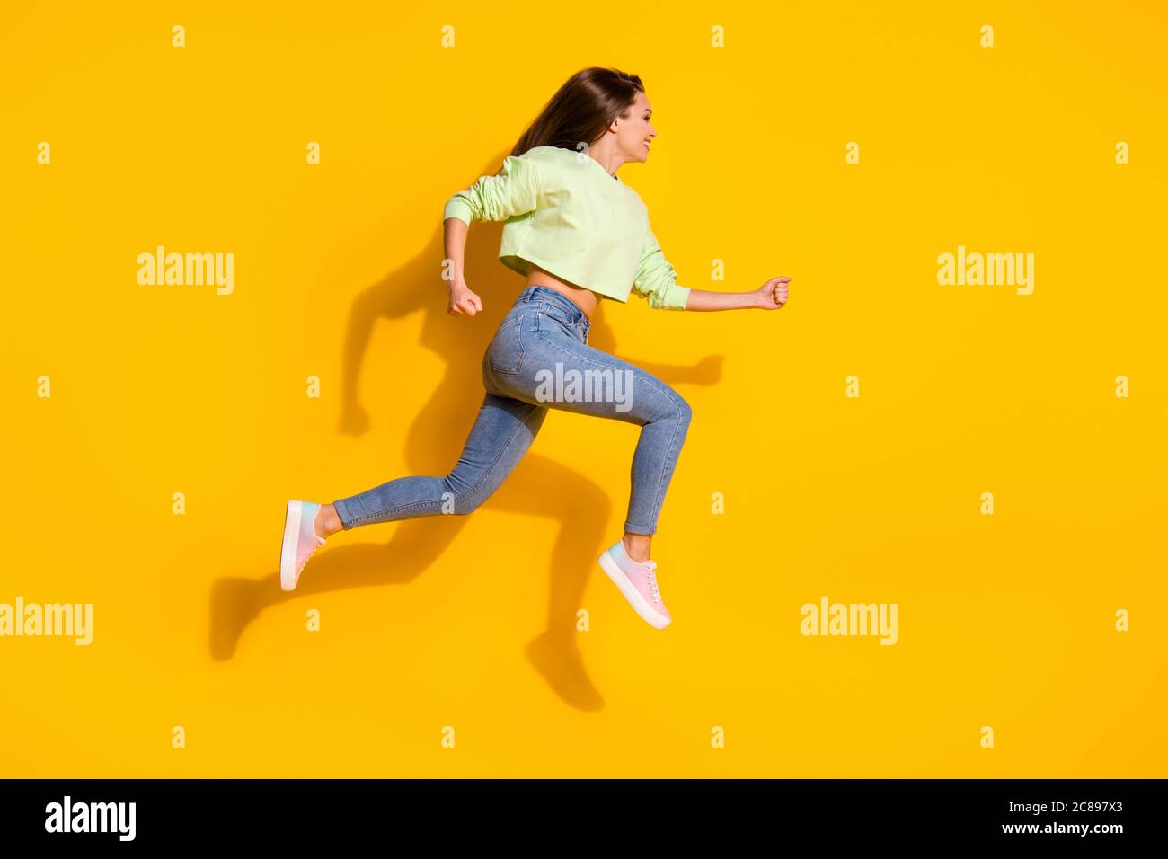 Full size profile side photo of cheerful girl jump run fast speed hurry ...