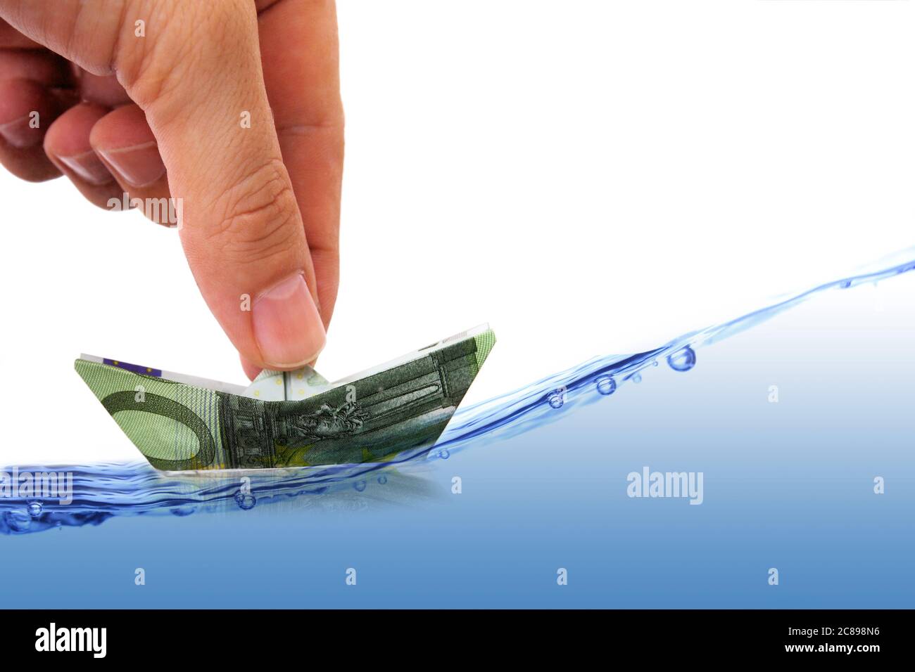 hand with money boat on wavy water Stock Photo - Alamy