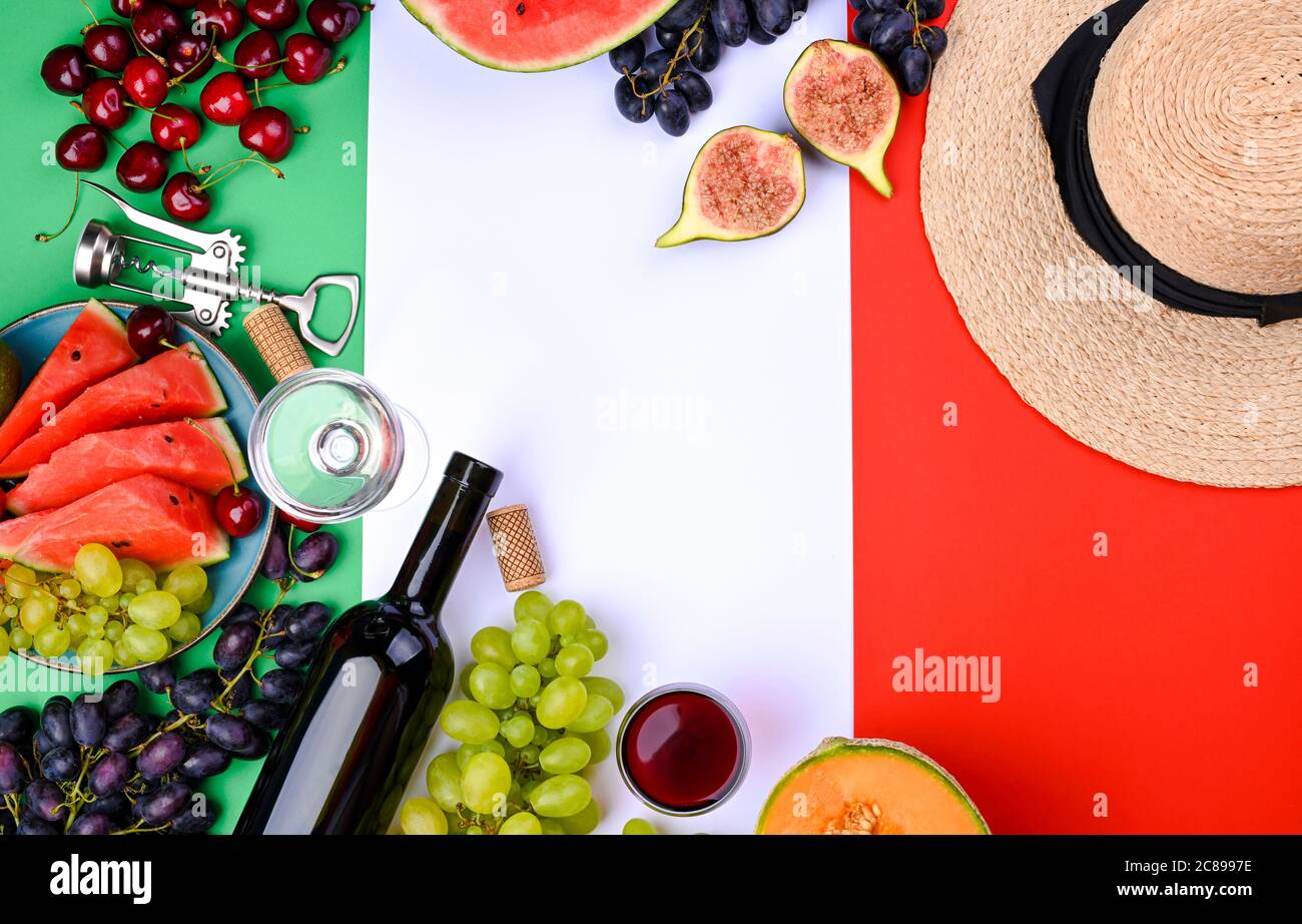 A bottle of wine, wineglass, grapes, different fruits and the flag of ...