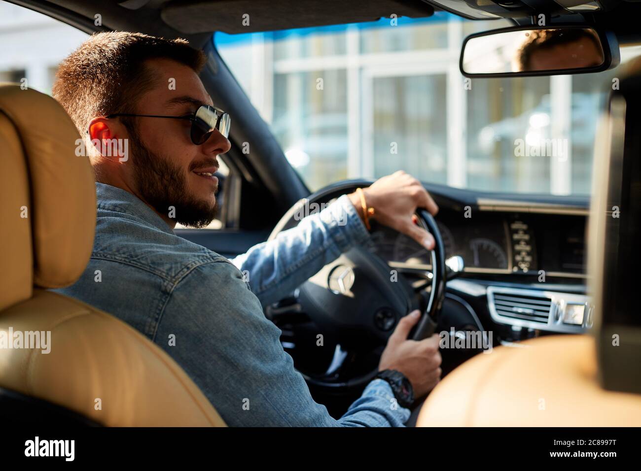 sporty brutsl man in sunglasses is looking at the traffic light while ...