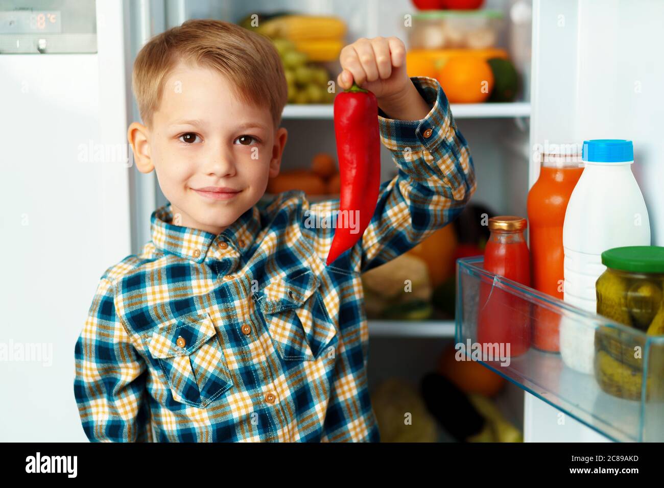Little boy standing in front of open fridge and choosing food Stock ...