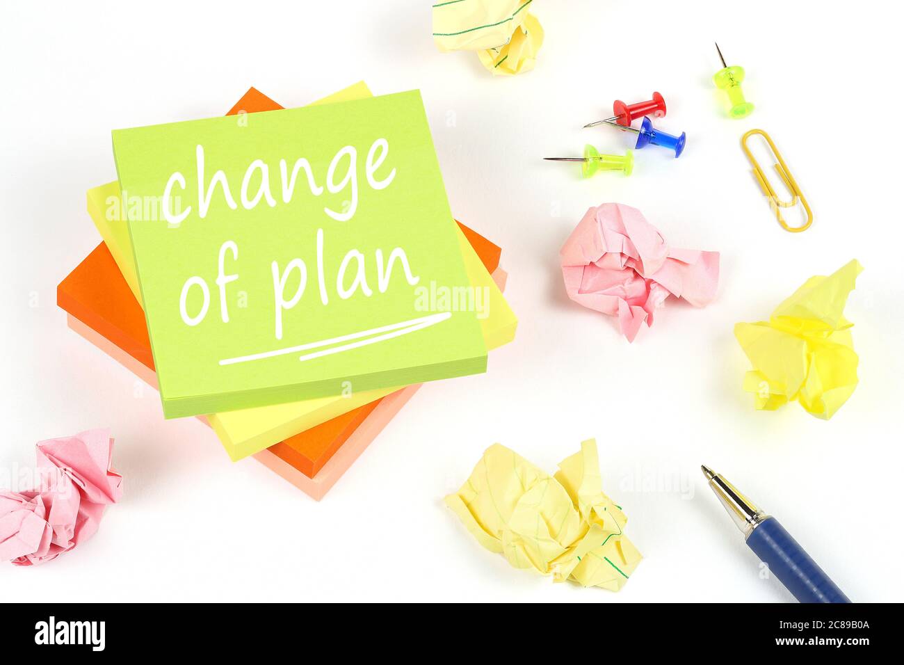 change of plan written on adhesive notes with crumpled paper and pen on ...