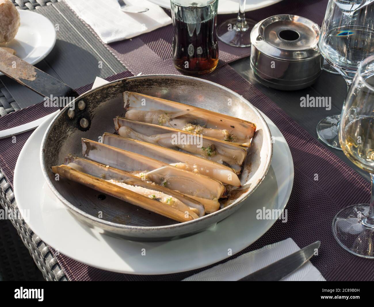 Atlantic jackknife razor clams close up served on cooking pan on sea ...