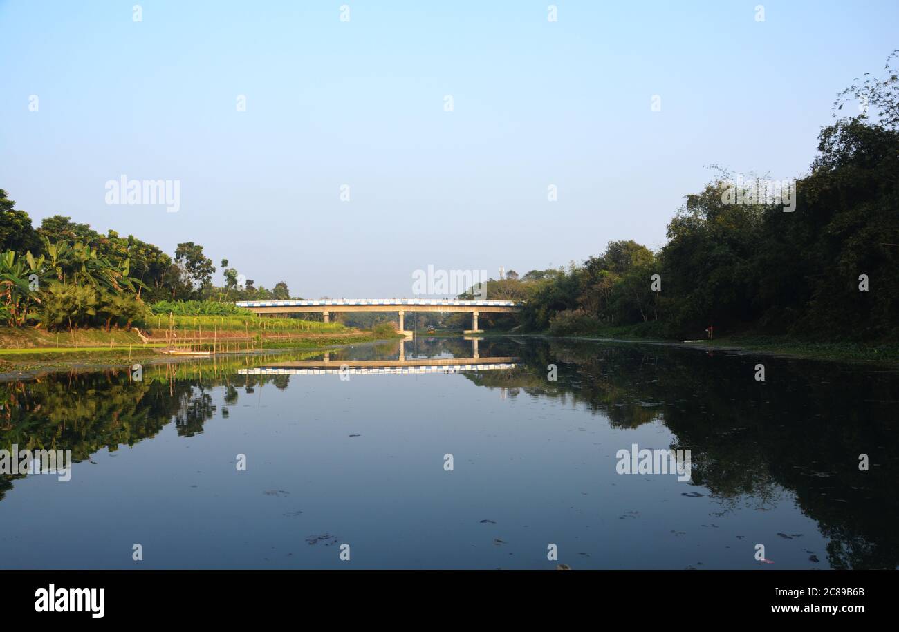 A concrete cement bridge with pillars on a village river, selective ...