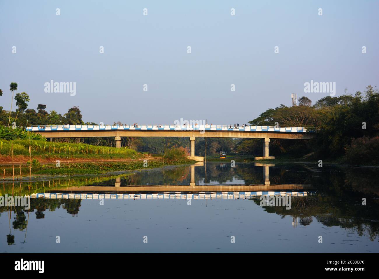 A concrete cement bridge with pillars on a village river, selective ...