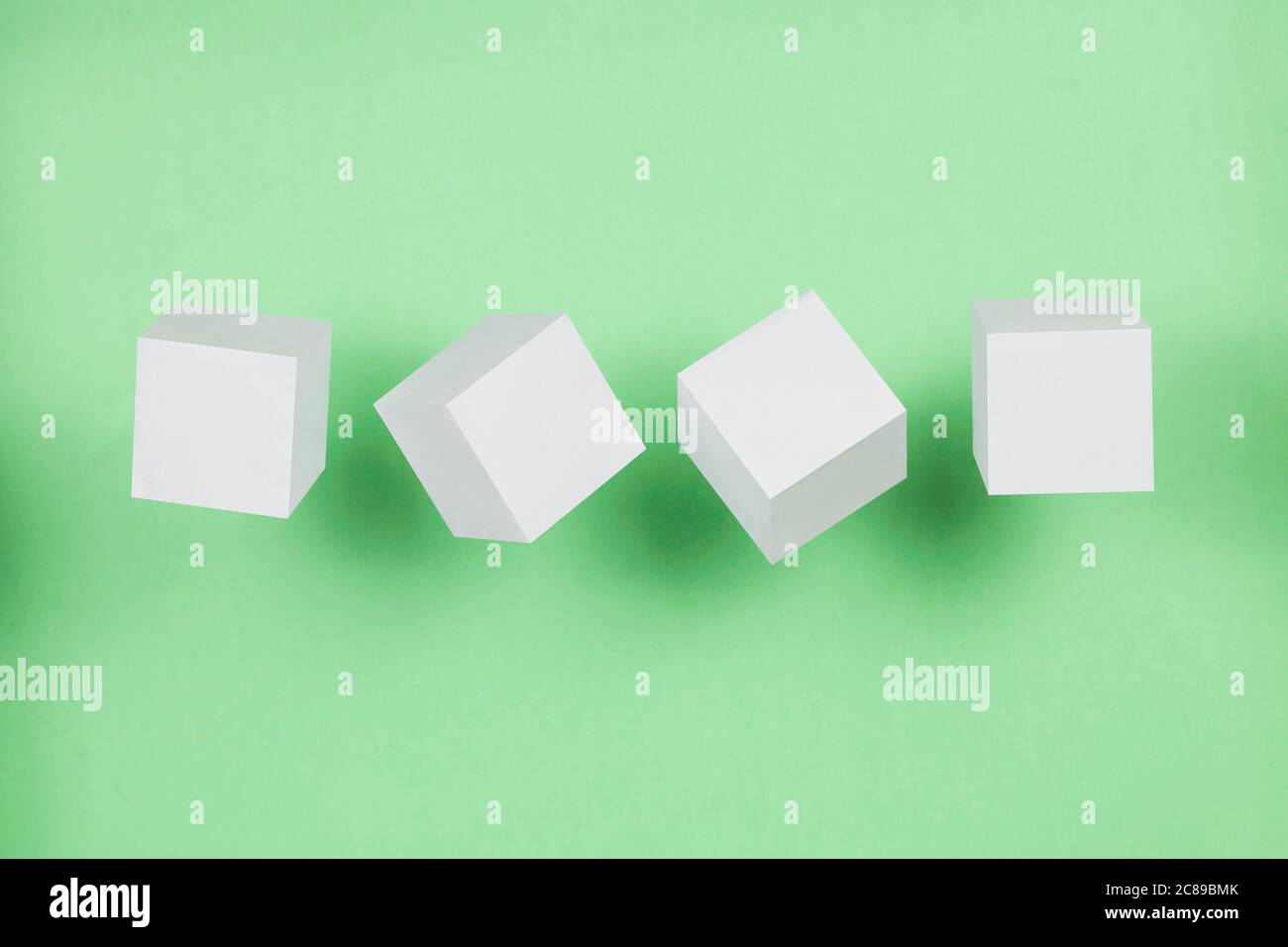 white paper cubes floating against green surface Stock Photo - Alamy
